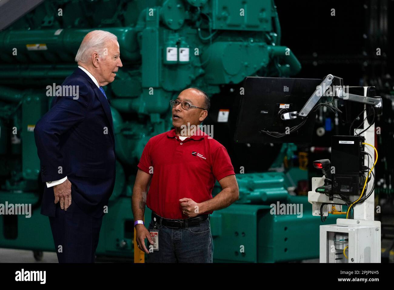 President Joe Biden listens as he tours the Cummins Power Generation ...