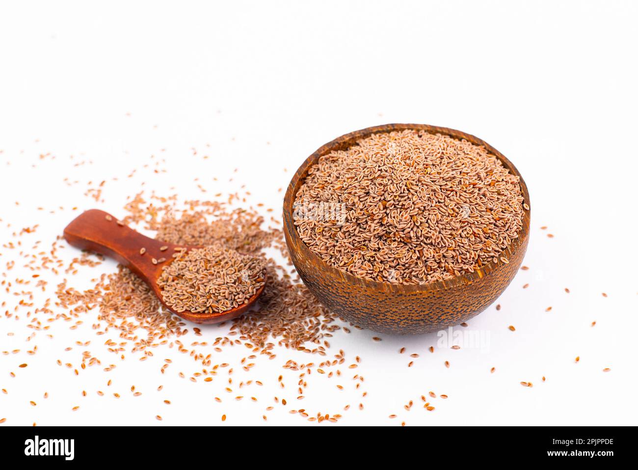 Flea seeds in a bowl, psyllium husks isolated on a white background ...