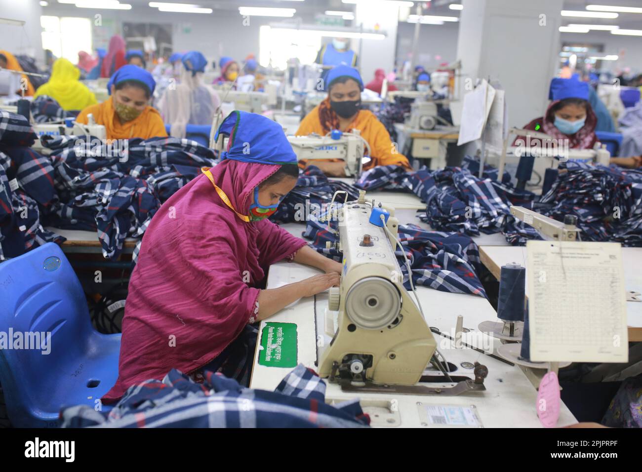 Garment workers work at a ready-made garment factory in Bangladesh ...