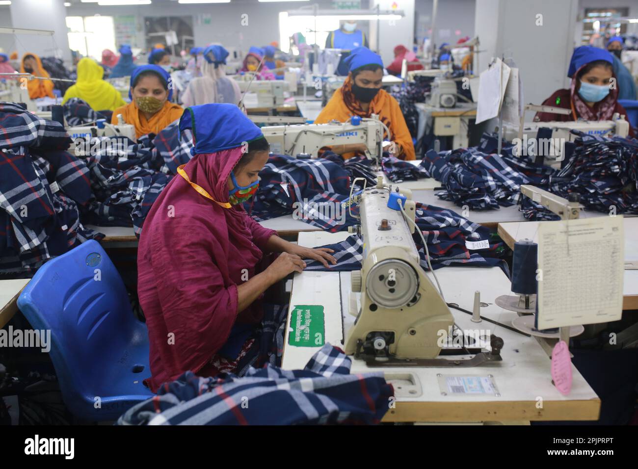 Garment workers work at a ready-made garment factory in Bangladesh ...