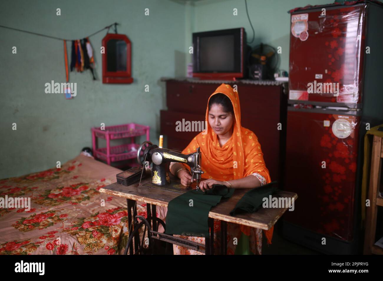 A garment worker works at home in Bangladesh Stock Photo - Alamy