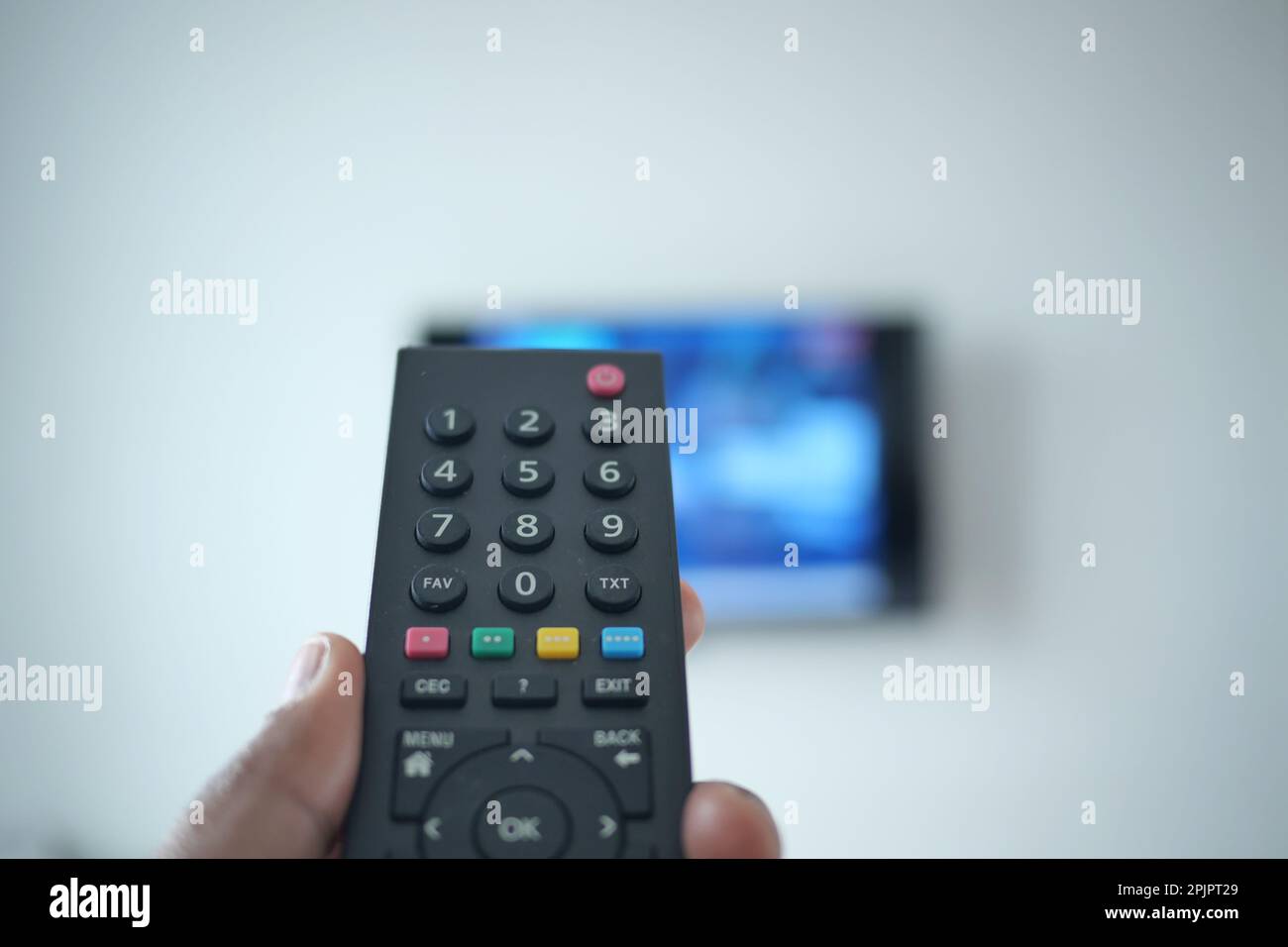 pov shot of man hand holding tv remote Stock Photo - Alamy