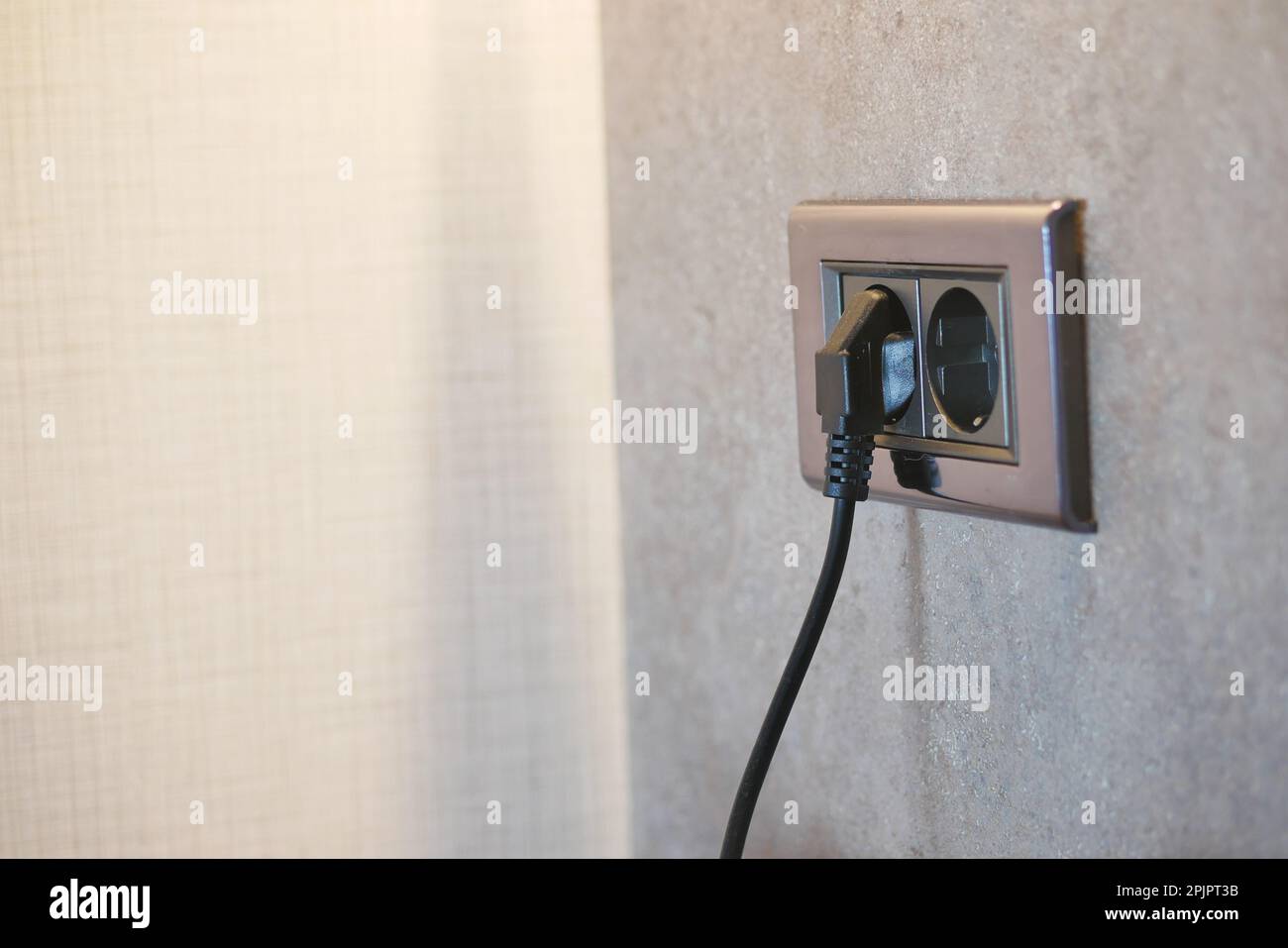 white color power cord cable plugged into wall Stock Photo - Alamy