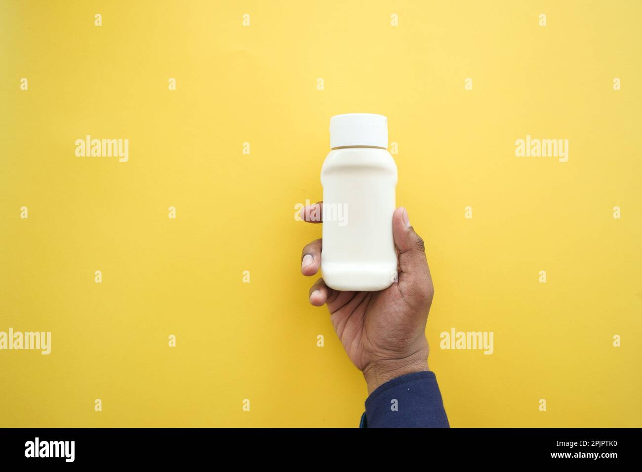 holding a Mayonnaise in container on yellow background Stock Photo - Alamy