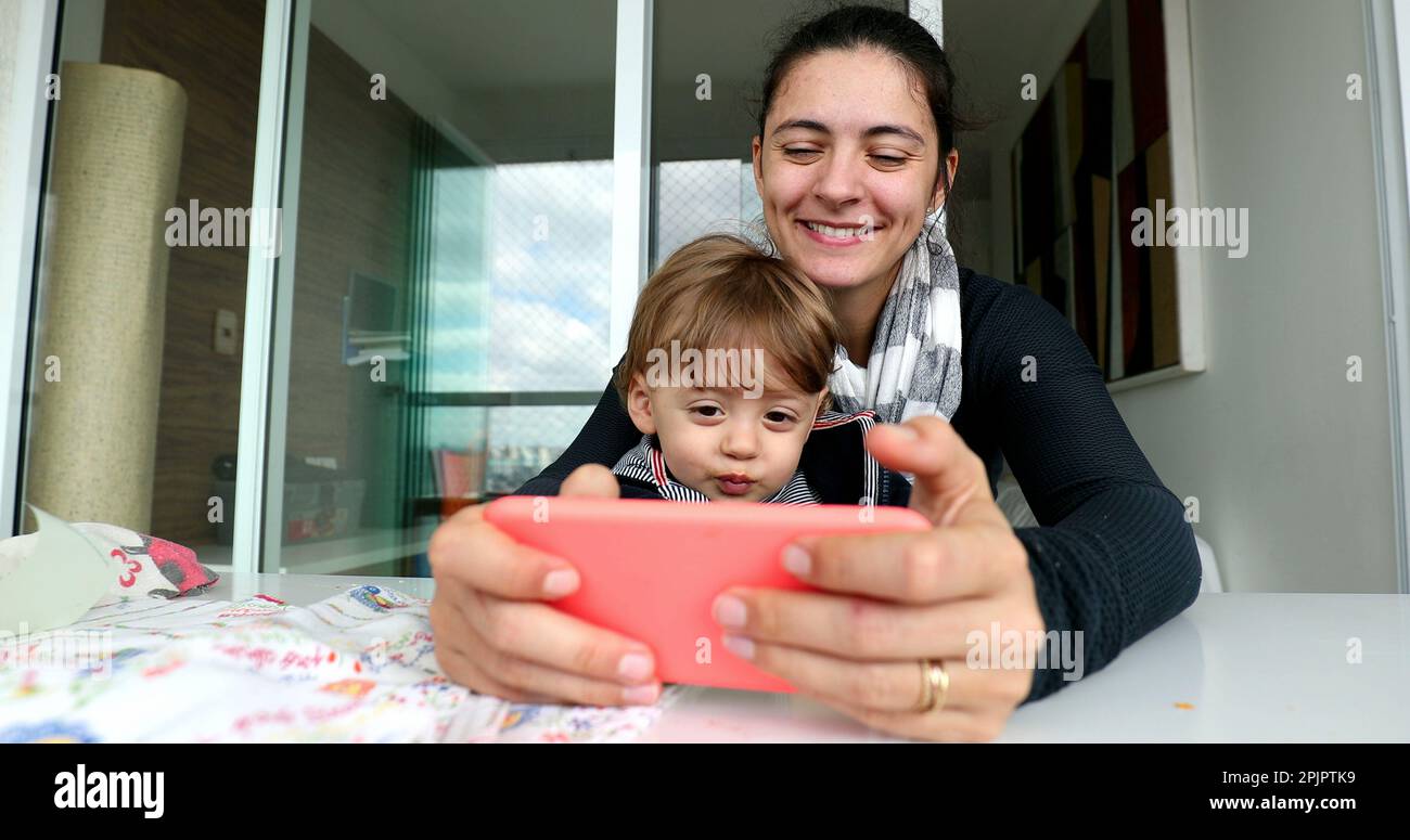 Parent and child using cellphone. Mother and toddler holding smartphone ...