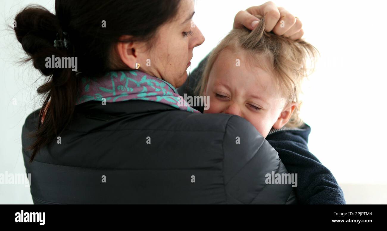 Mother holding crying baby toddler. Mom caring calming down tearful ...