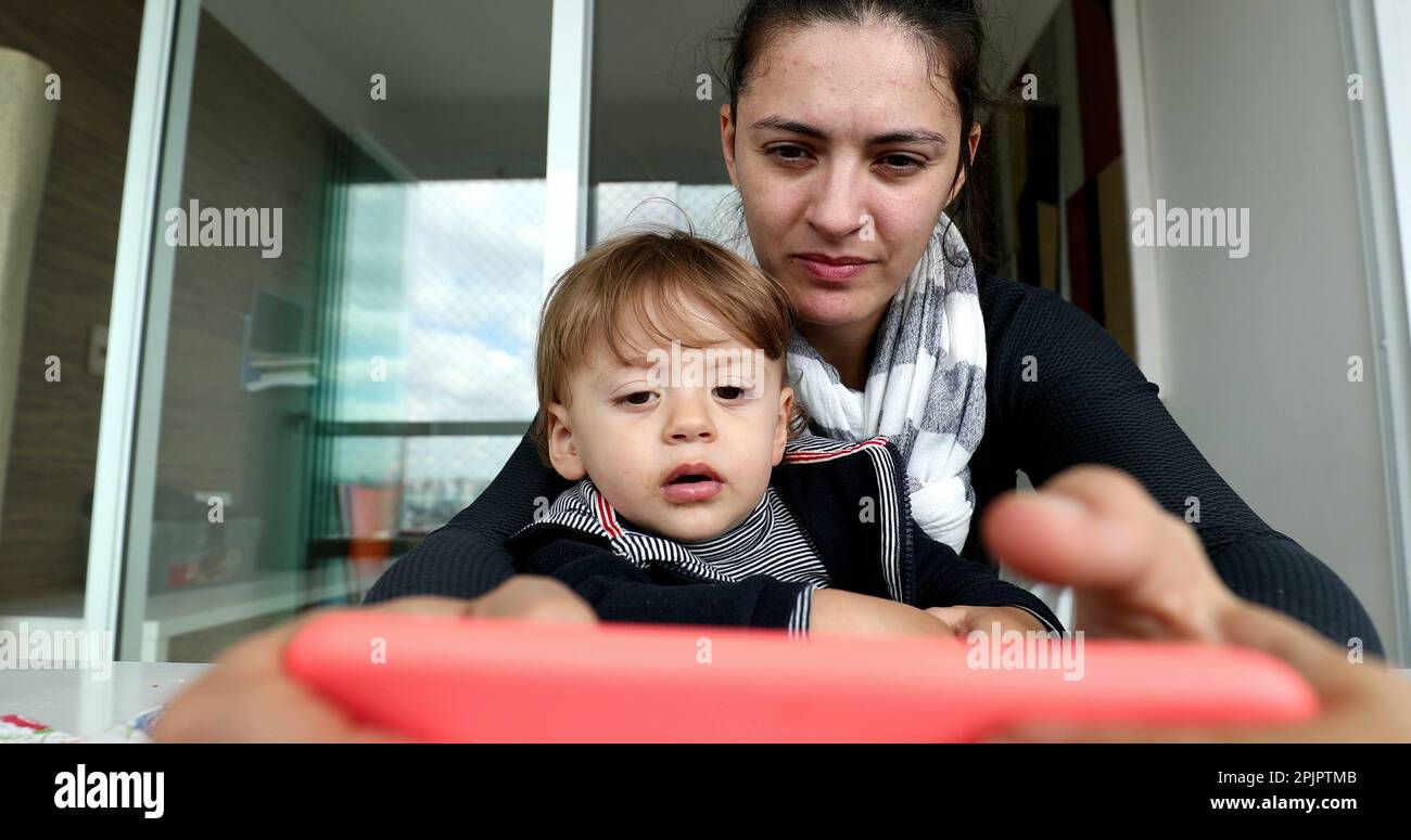 Parent and child using cellphone. Mother and toddler holding smartphone ...