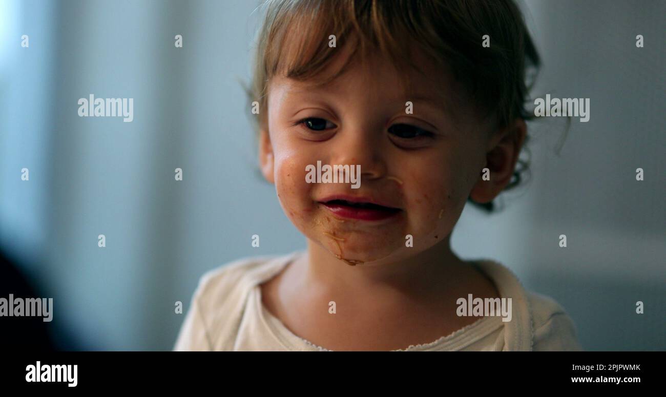 Portrait of messy baby infant child. Dirty boy made a mess after meal ...
