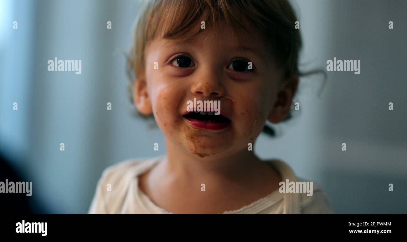 Portrait of messy baby infant child. Dirty boy made a mess after meal ...