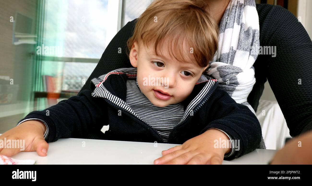 Toddler boy on mother lap, parent holding cellphone multi-tasking Stock ...