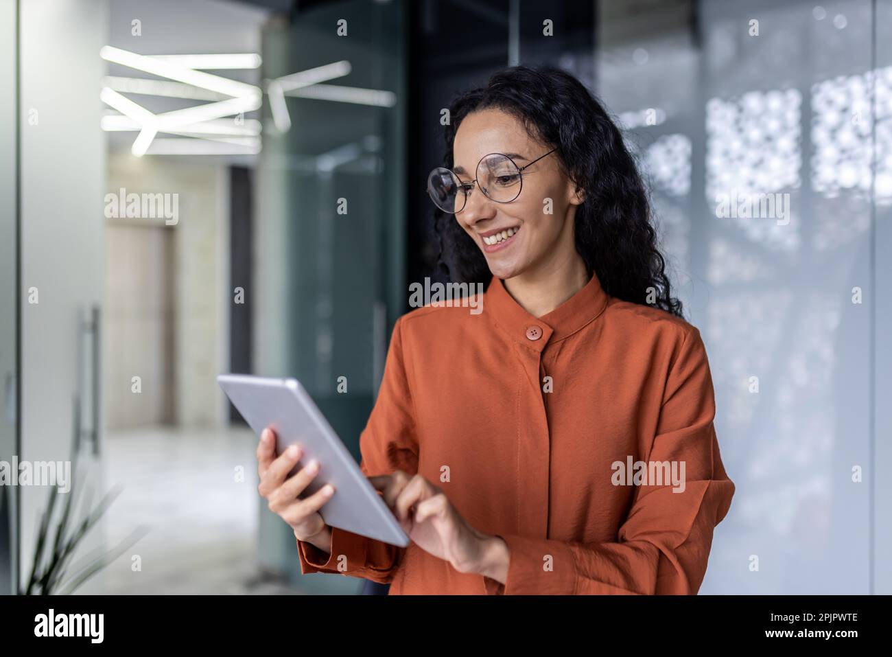 Latin american female programmer inside office standing near window ...