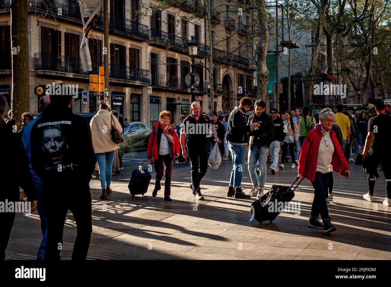 Wheeled suitcases are pushed down La Rambla in Barcelona. During this ...