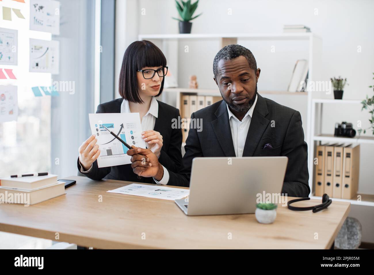 Businesspeople in formal wear looking into computer webcam while ...