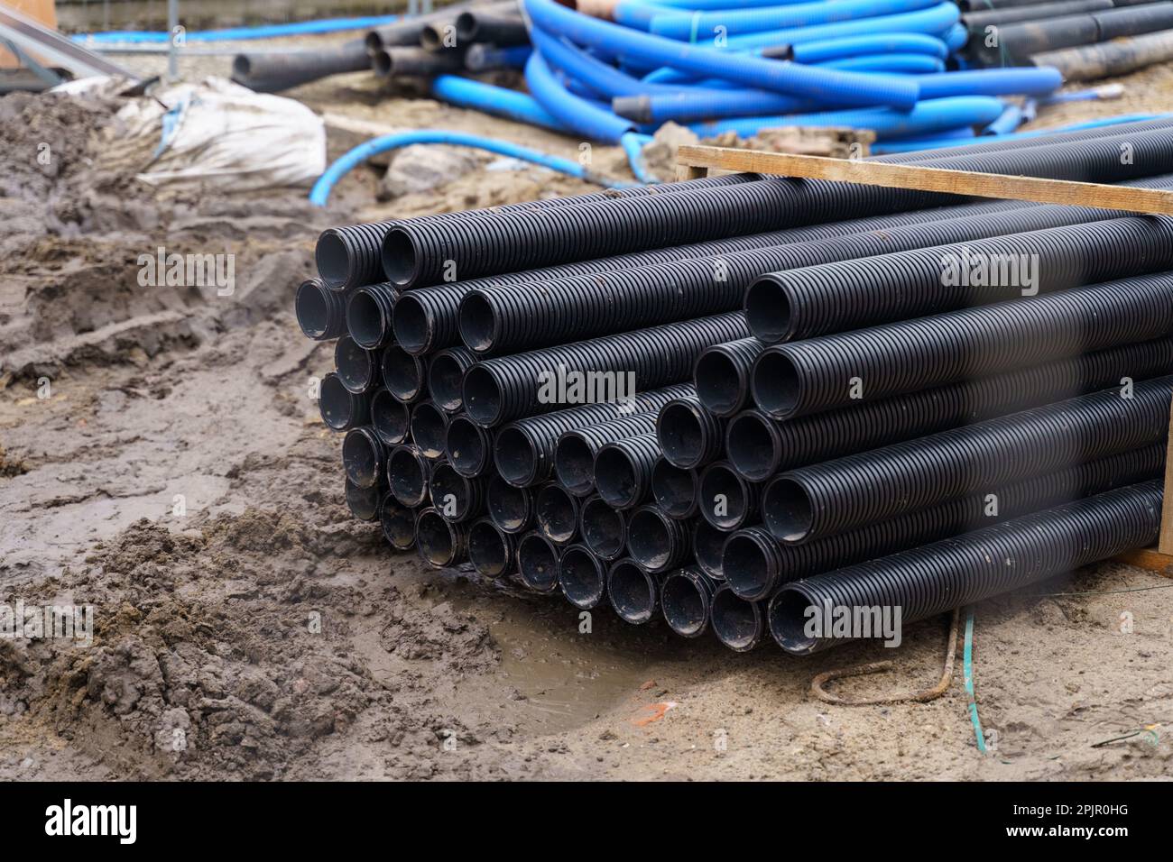 Blue and black corrugated pipelines of various diameters lie on a ...