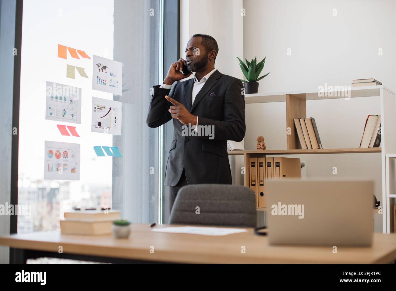 Multiethnic businessperson in formal outfit having conversation on cell ...