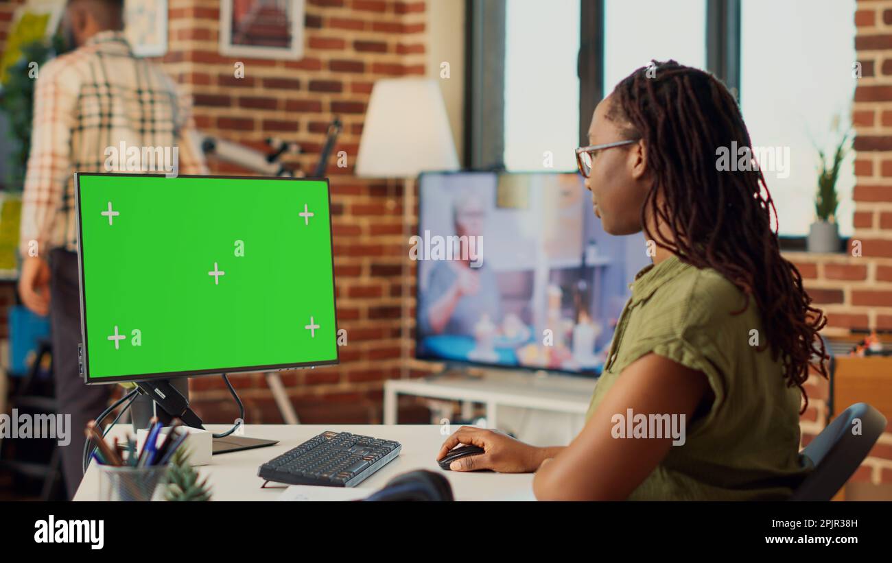 Corporate worker looking at greenscreen display on computer, working ...