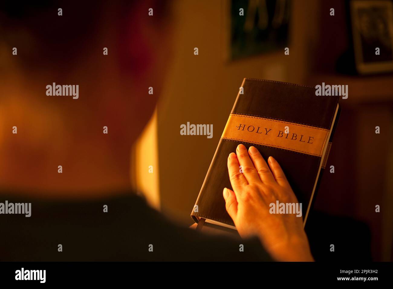 Woman with hand touching Bible Stock Photo - Alamy