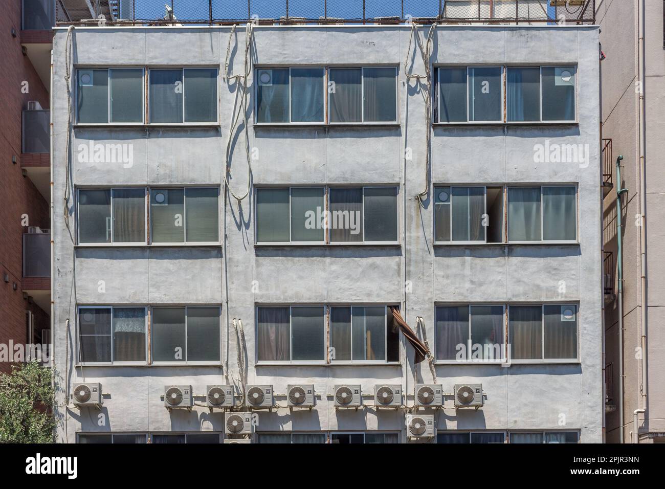 Symmetrical city apartment block with air-conditioning units. Tokyo ...