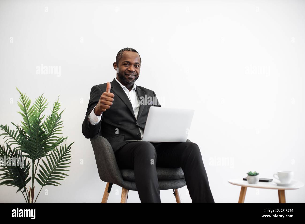 Diligent african employee in formal wear smiling sincerely at camera ...