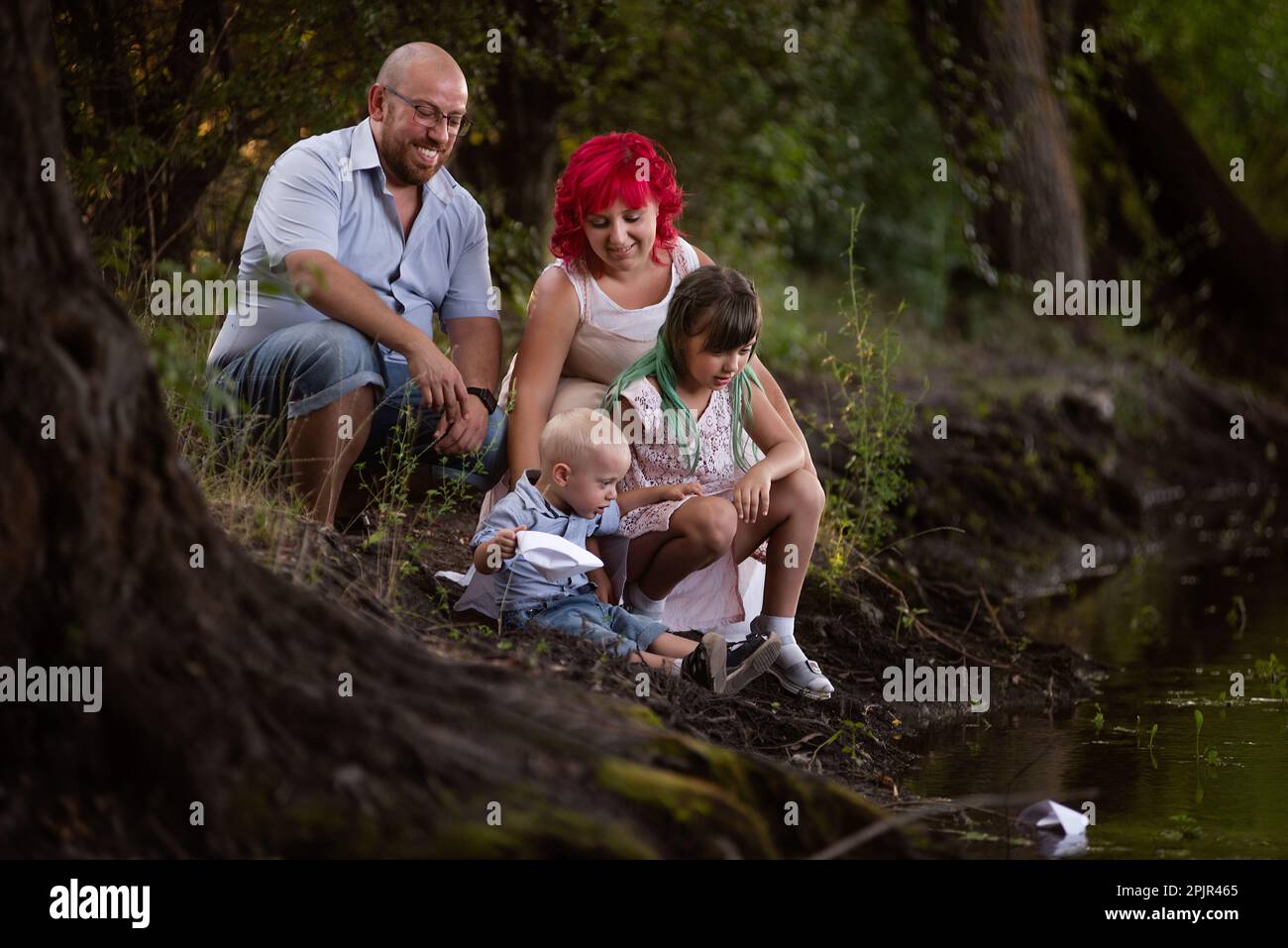 Close up portrait of diversity family of four launching white origami ...
