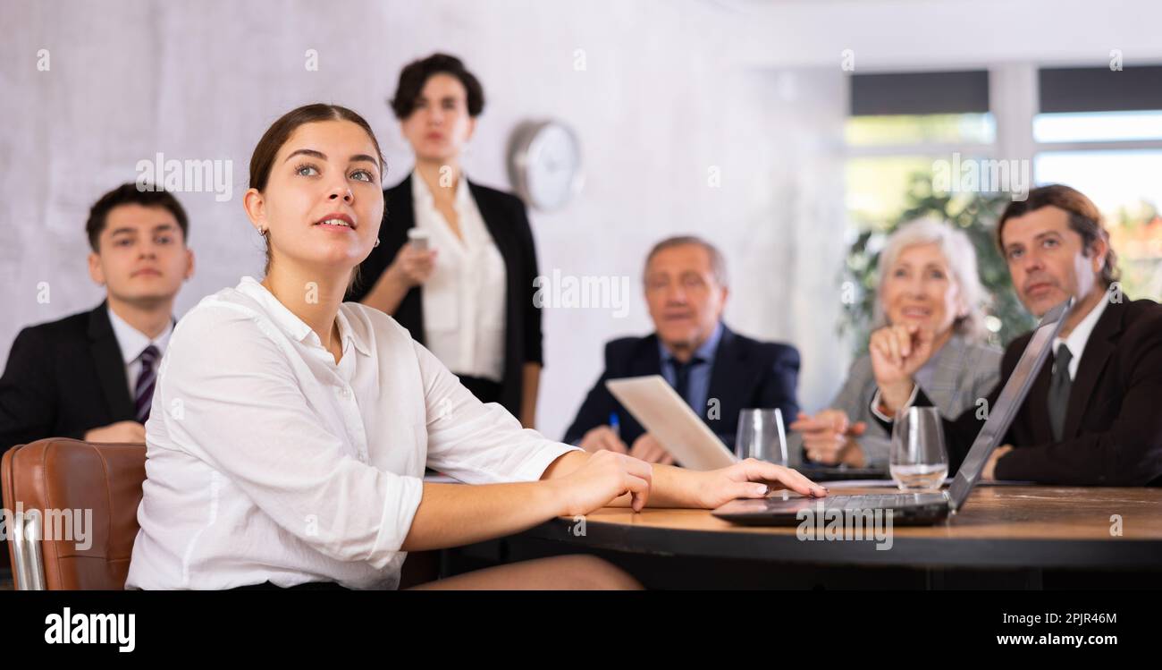Office coworkers of different ages watching presentation while sitting ...