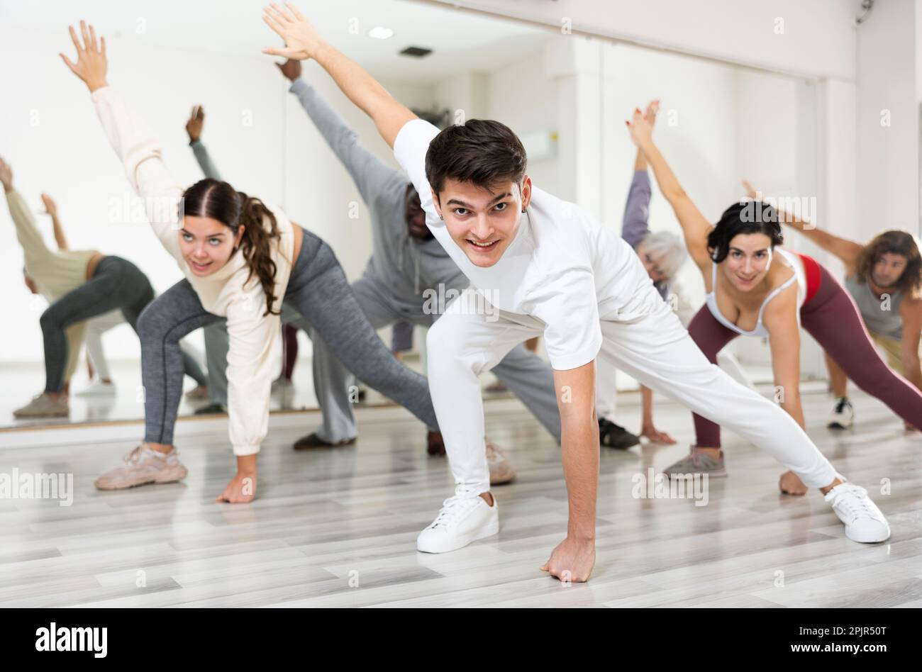 Group of active people performing a stretching exercise Stock Photo - Alamy