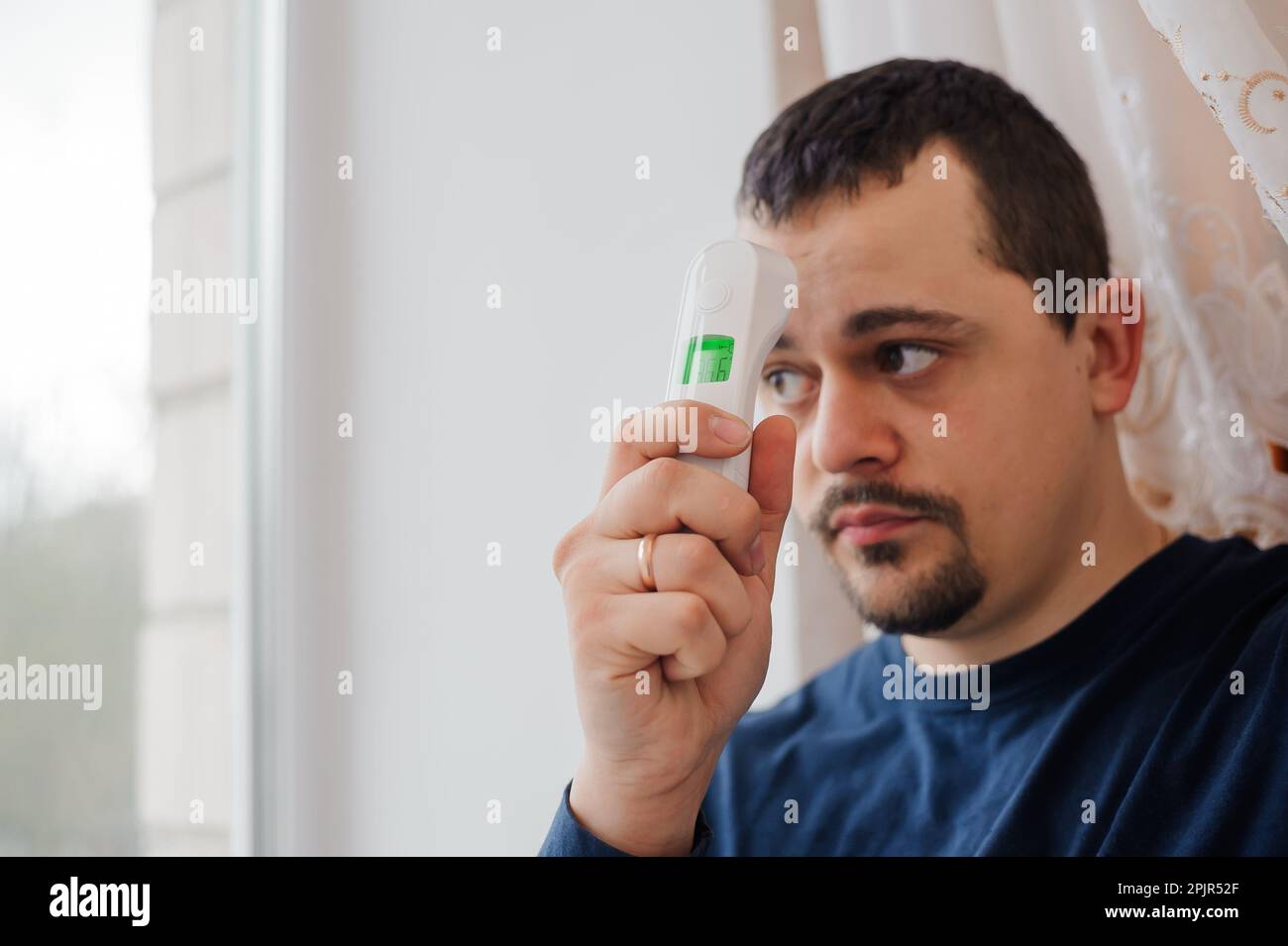 Non-contact thermometer in the hands of a man. Man measures body ...