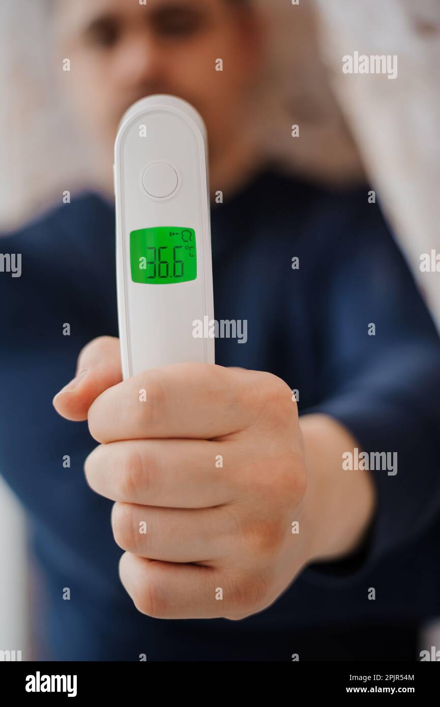 Non-contact thermometer in the hands of a man. Man measures body ...