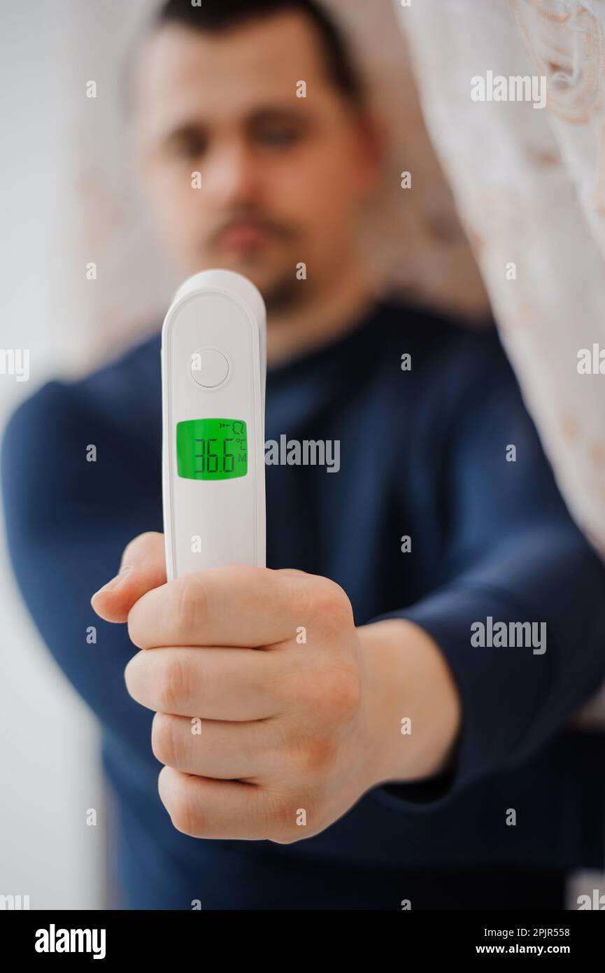 Non Contact Thermometer In The Hands Of A Man Man Measures Body