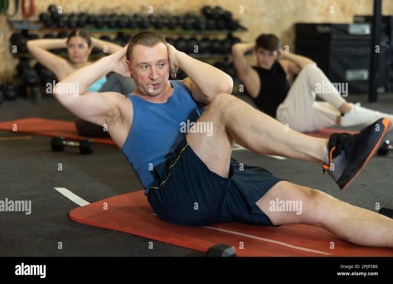 Focused man performing bicycle crunches during workout in gym Stock ...