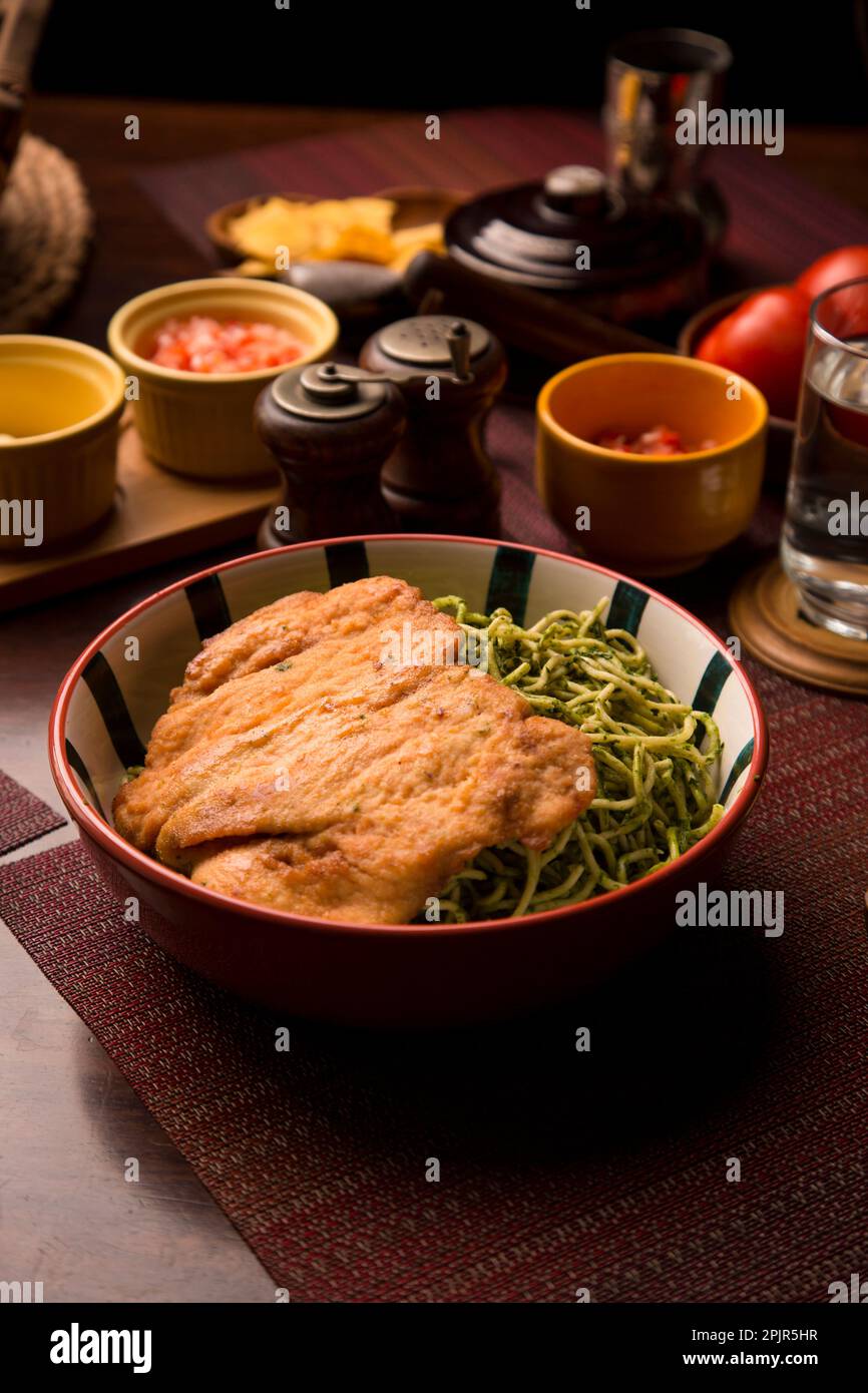 Green pasta with fried chicken Peruvian food buffet table Assorted ...