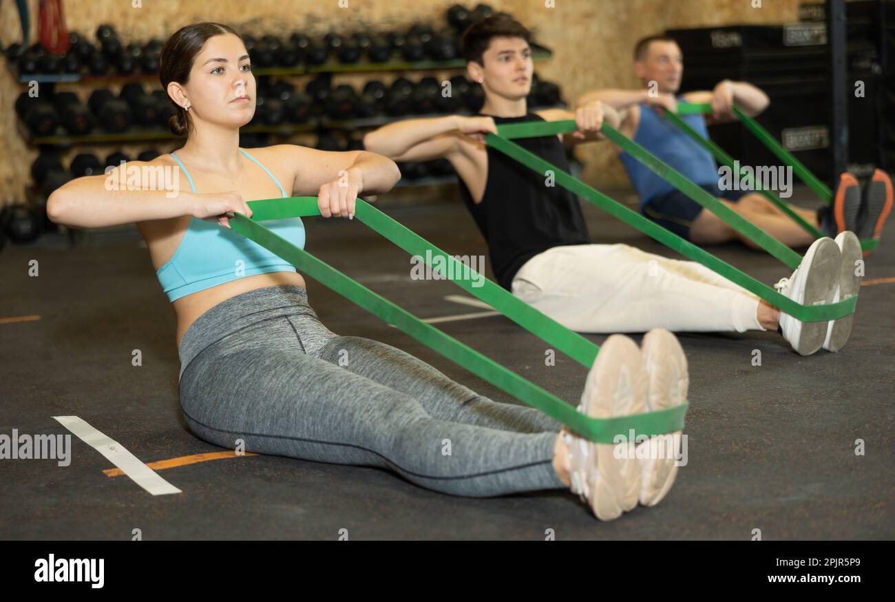 Focused young girl exercising with resistance band loop in gym Stock ...
