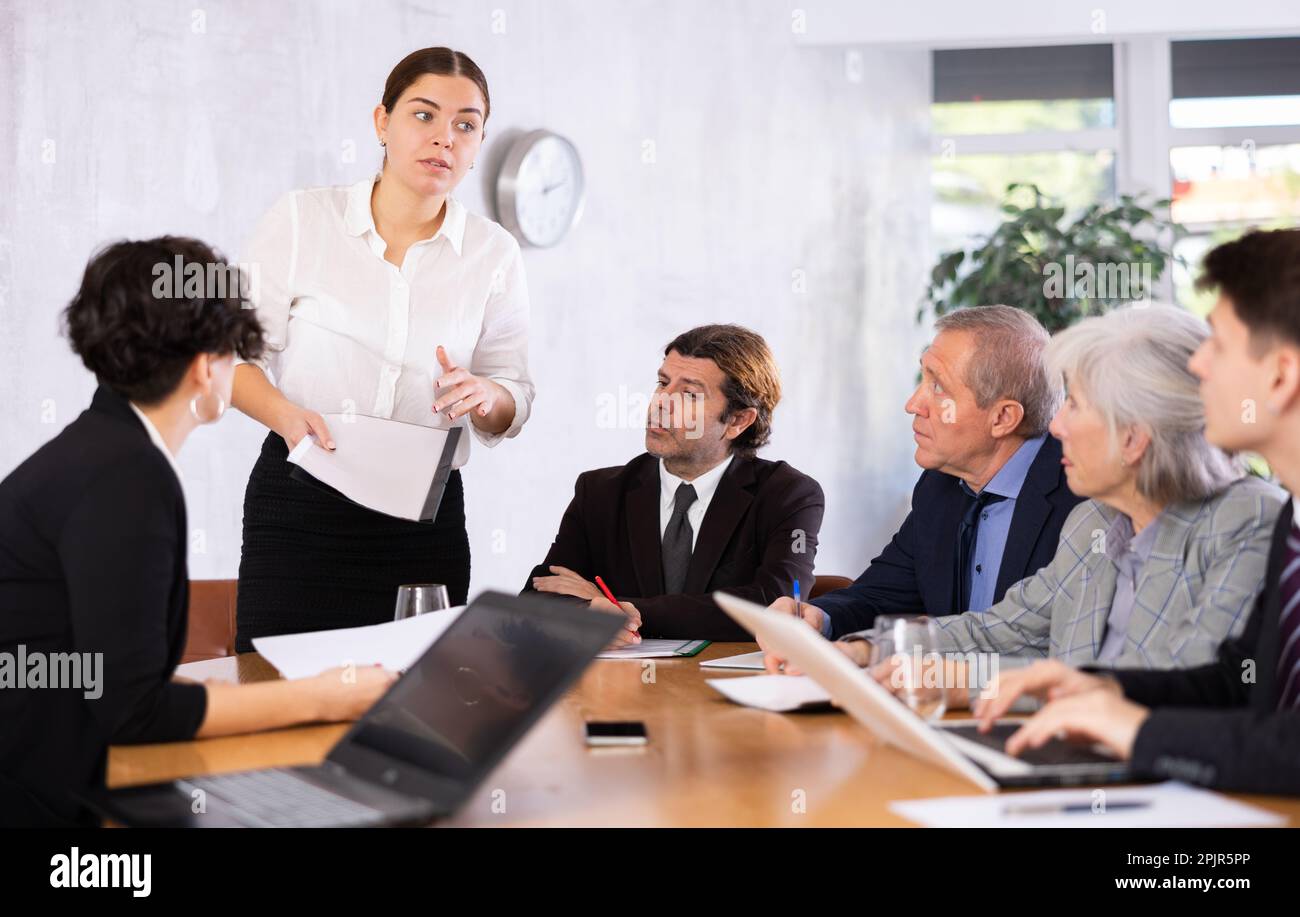 Female director gives instructions to managers in deliberation room ...