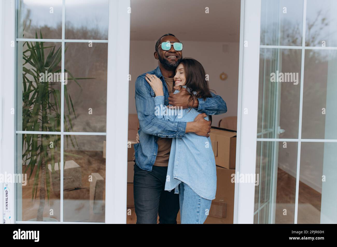 Happy young man hugging excited wife celebrating moving day with ...