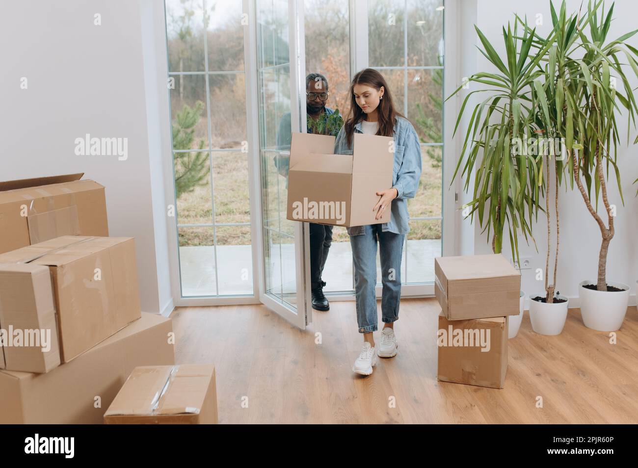 A young couple moves into a new house. an African-American man and his ...