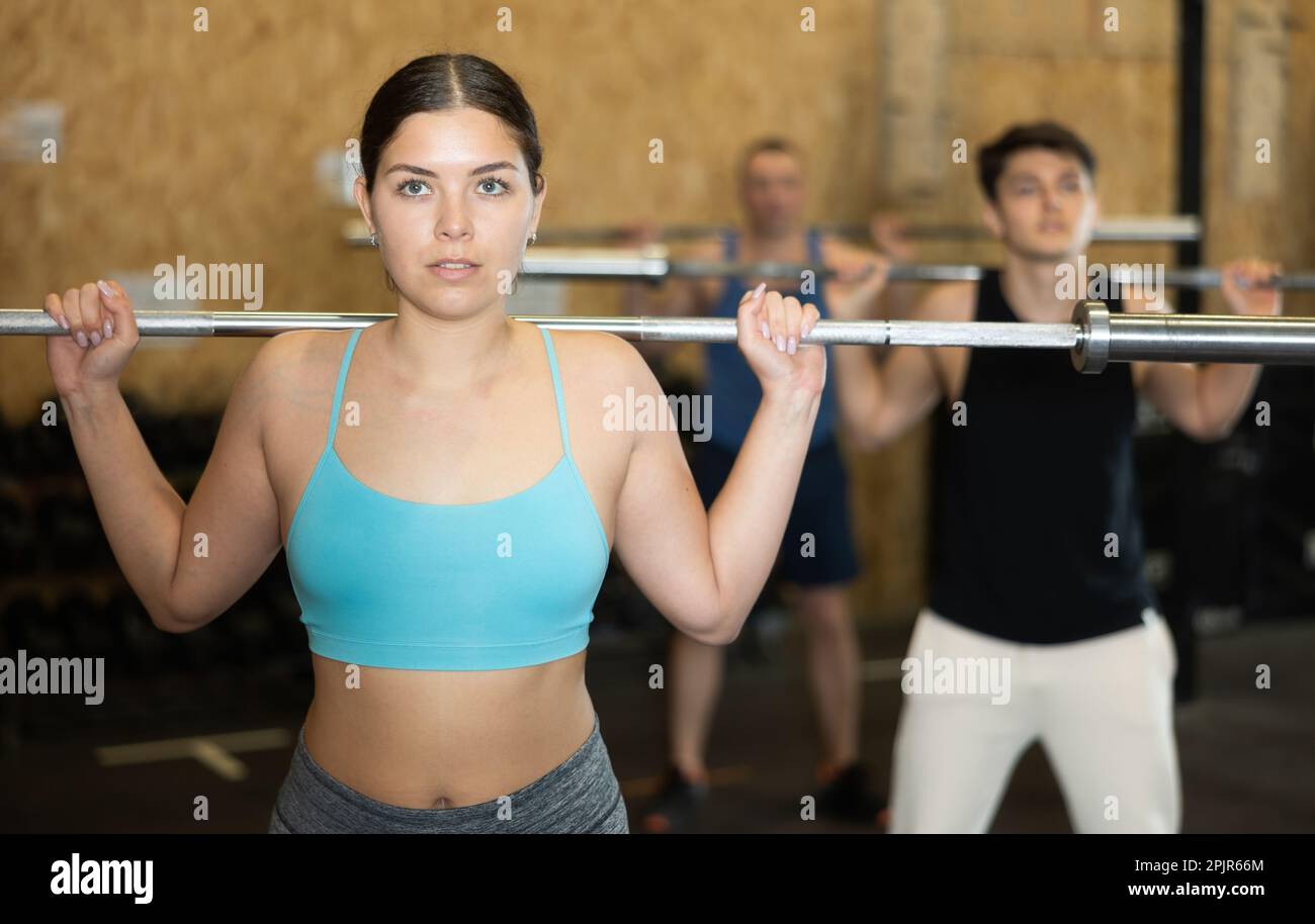 Young female bodybuilder performing strength and endurance exercises ...