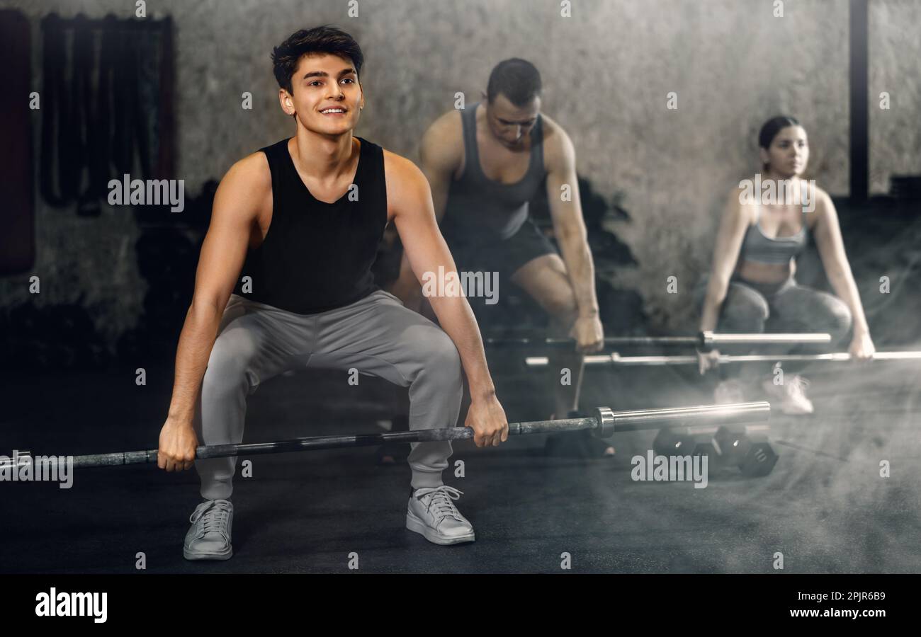 Smiling sporty guy performing deadlift with barbell in gym Stock Photo ...