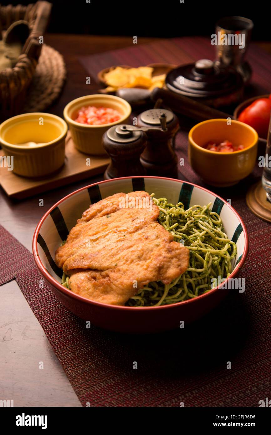 Green pasta with fried chicken Peruvian food buffet table Assorted ...