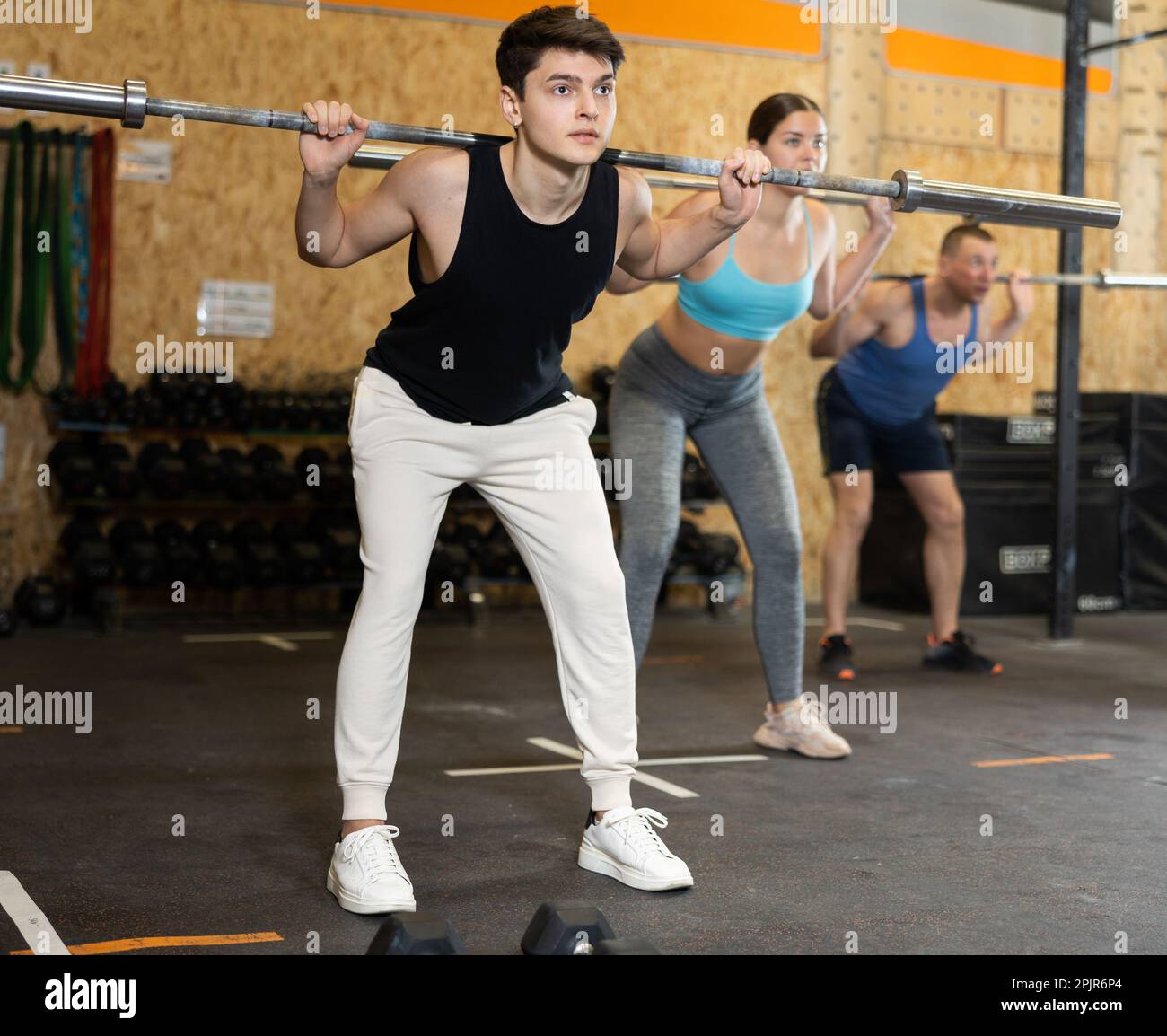 Athletic guy doing exercises with barbell in gym during workout Stock ...
