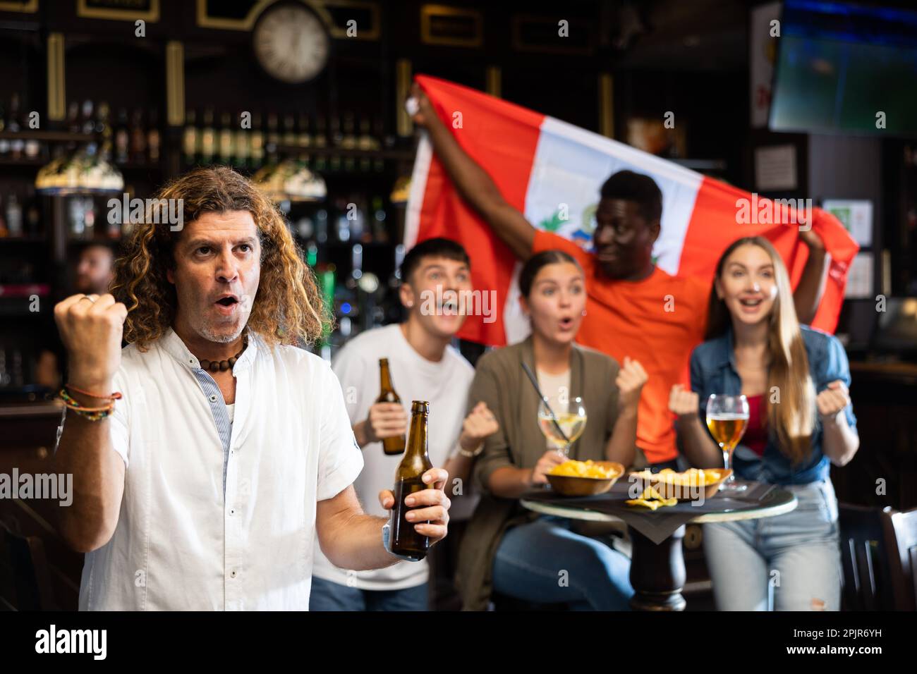 Cheerful diverse football supporters holding the flag of Peru and ...
