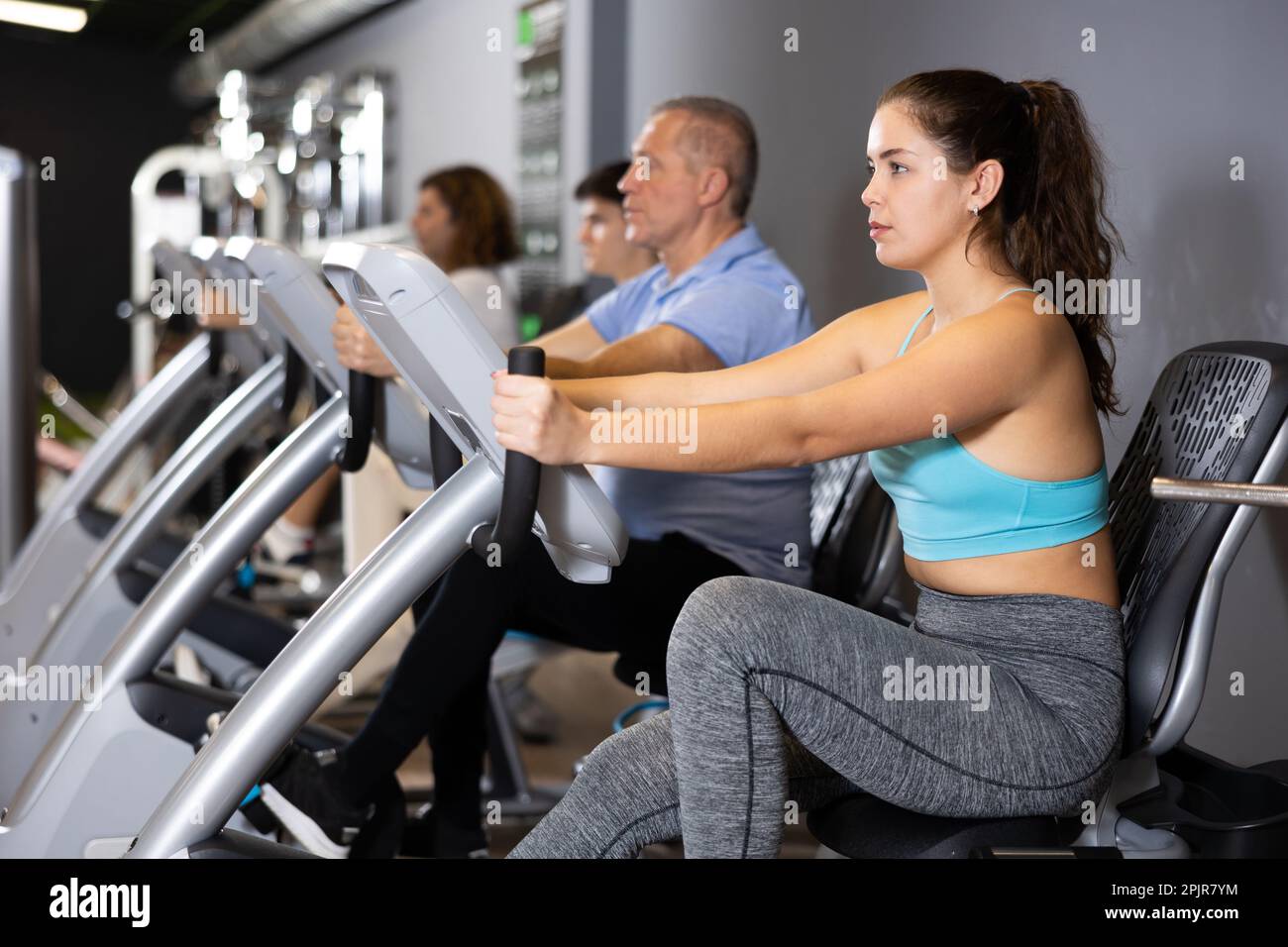 Young girl doing cardio training on stationary bike in gym Stock Photo ...