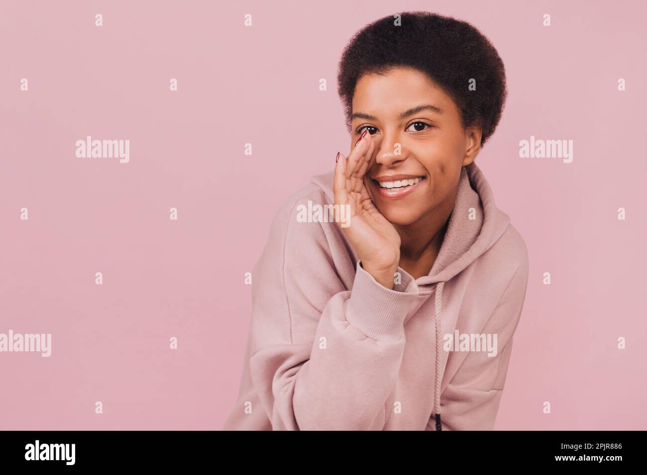 Close up portrait of young black woman has secret and press hand to ...