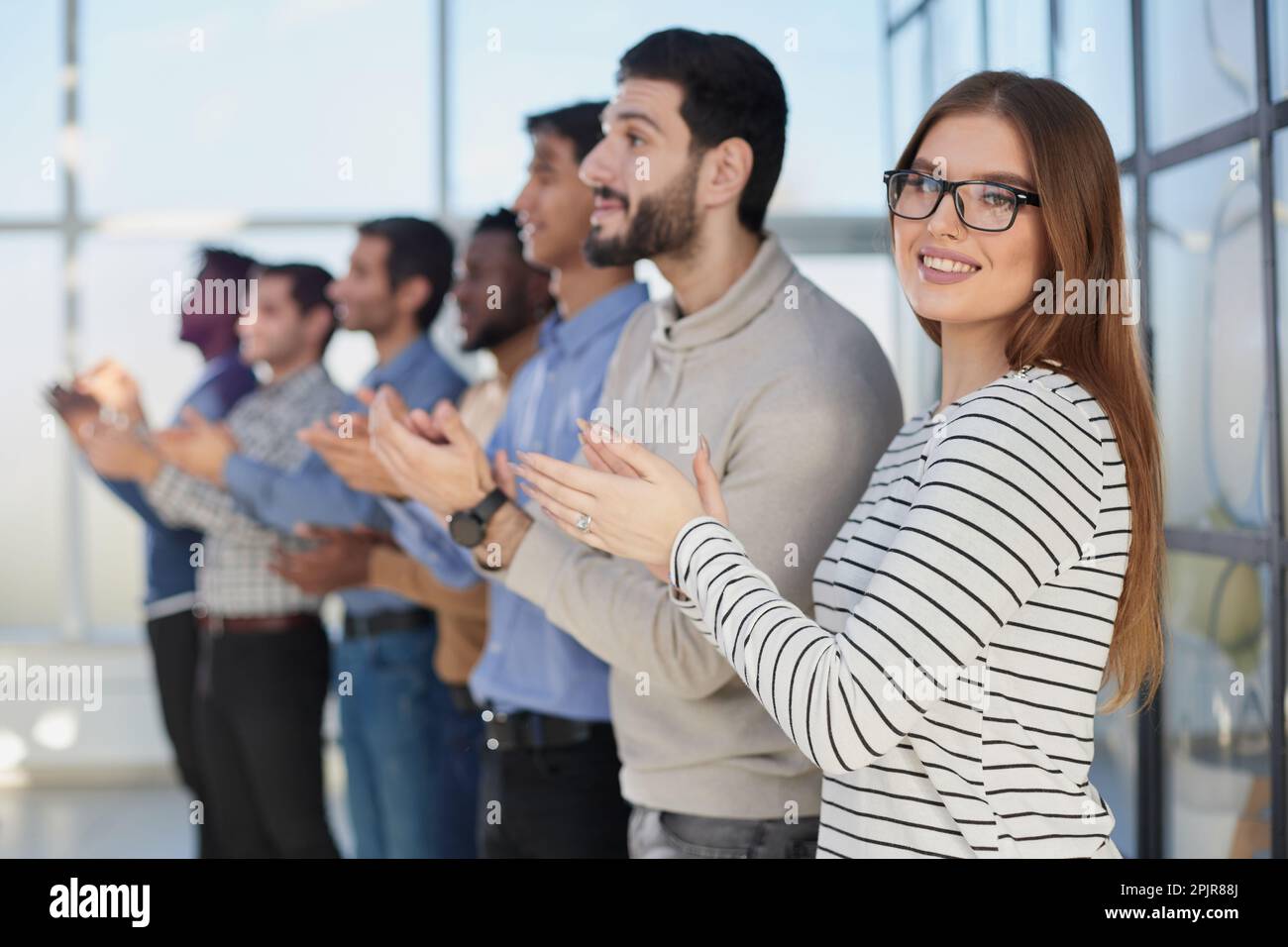 Business people applaud in a conference room standing in a row. Side ...