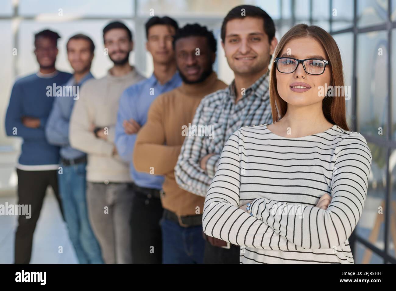 Portrait of multicultural office staff standing in the lobby in a row ...