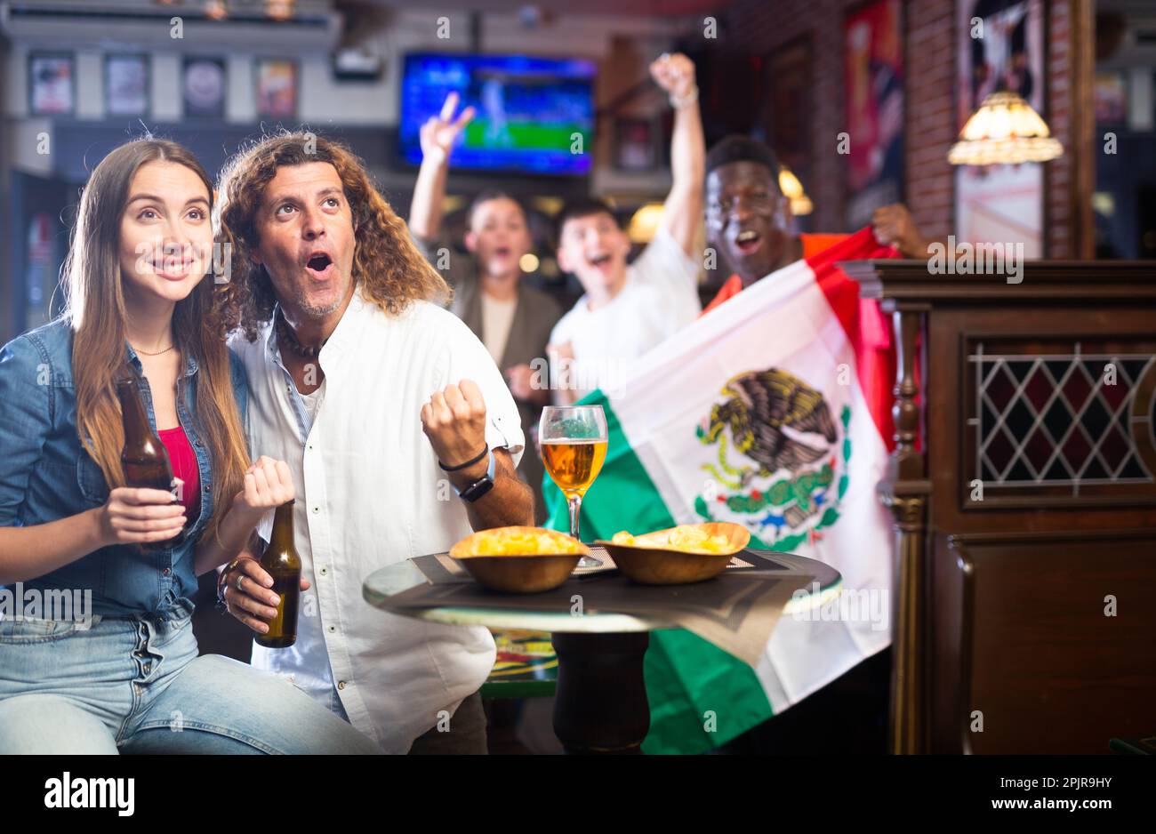 Happy international footbal supporters holding up the flag of Mexico ...