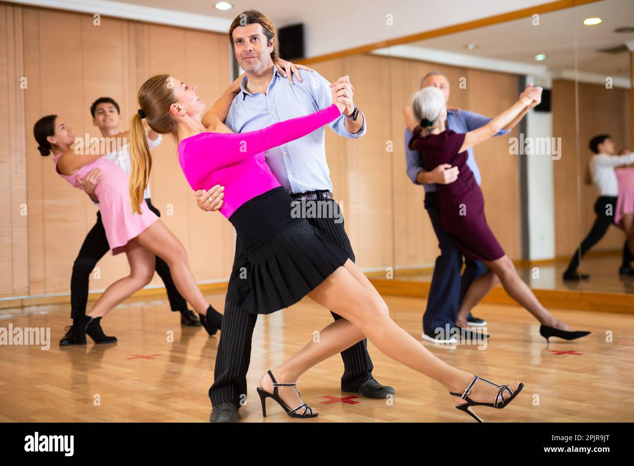 Middle-aged pair practicing ballroom dance in dance studio Stock Photo ...