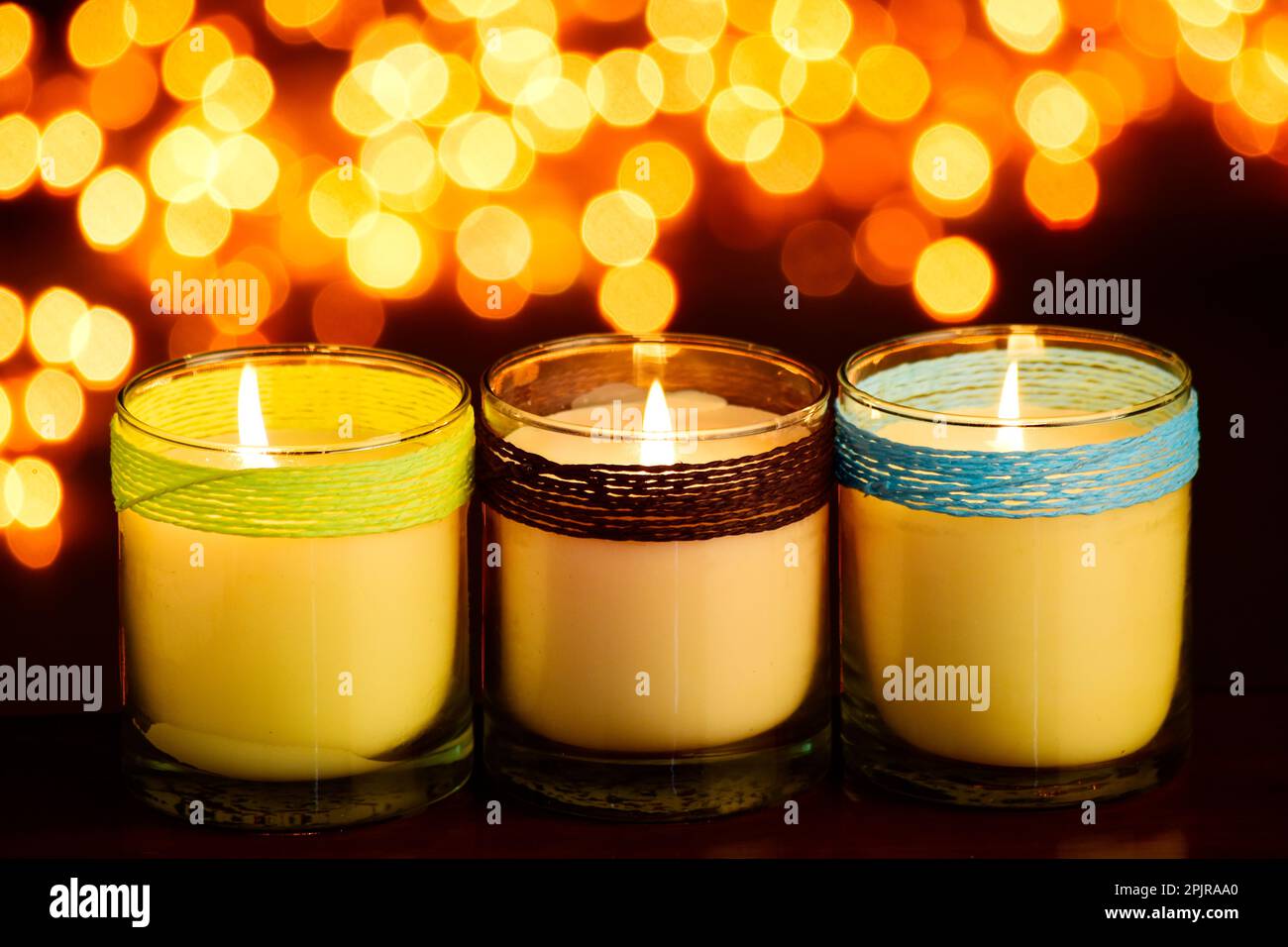 Set of beautiful candle jars at table with light bokeh background Stock ...