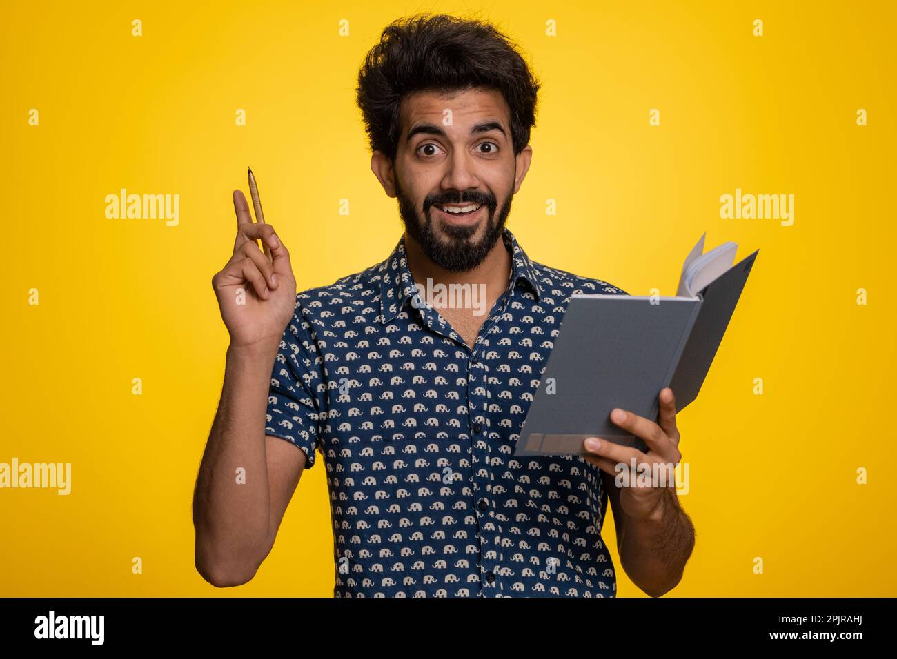 Thoughtful journalist indian man making notes, writing down thoughts ...