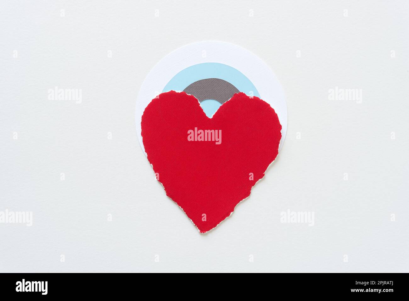 red paper heart with torn edge on various paper rings on blank paper ...