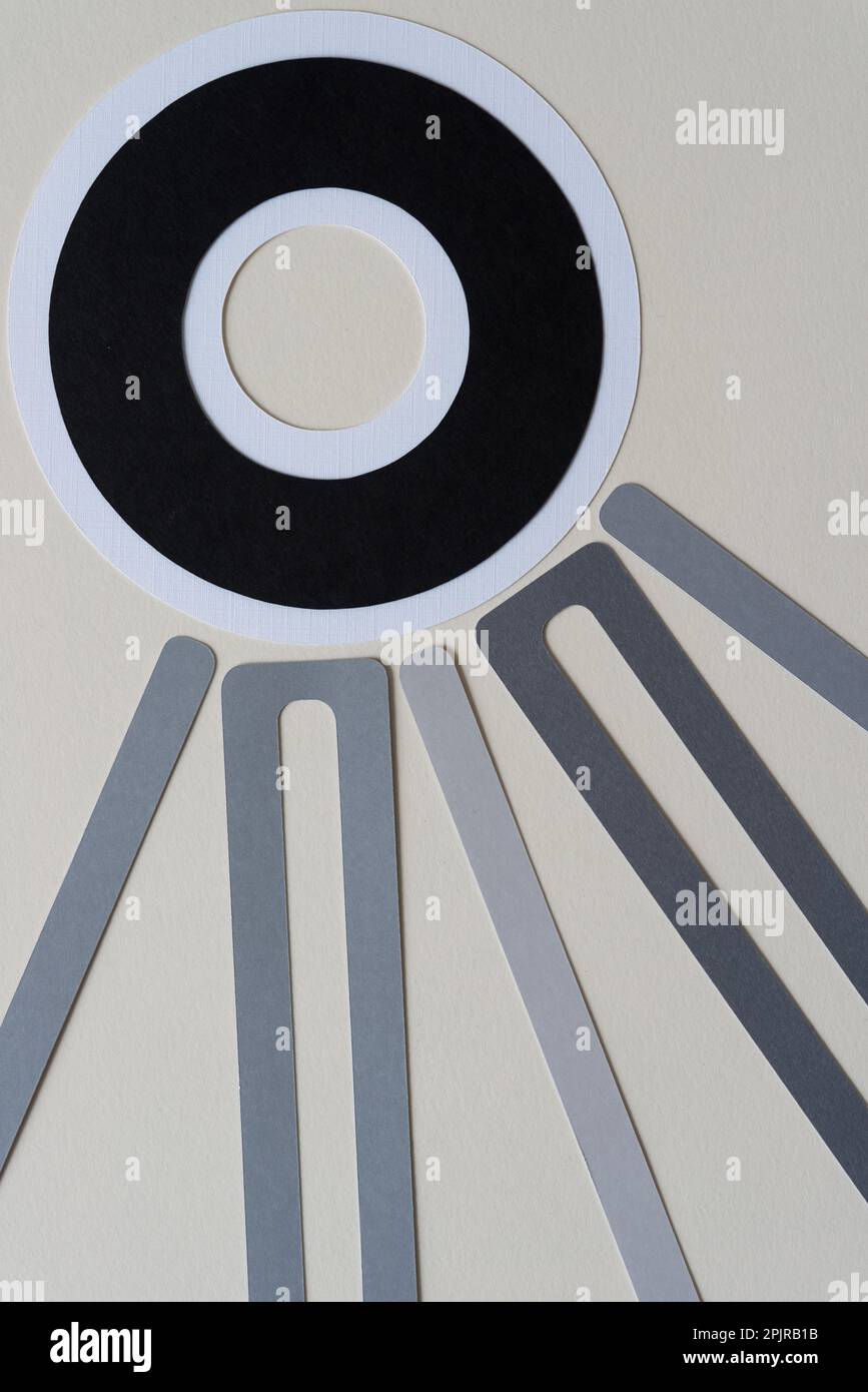 black on white paper rings and lengths of cut paper shapes arranged in ...
